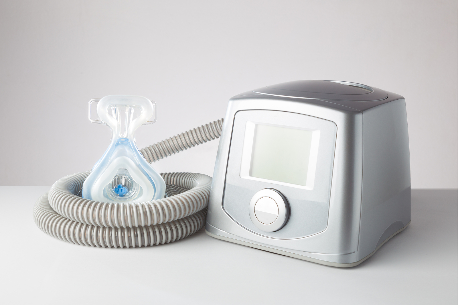 Sleep Apnea CPAP machine with hose and head hear mask on white table ...