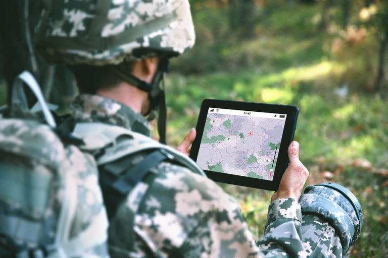 Soldier using GPS map on tablet for orientation at forest – InsideSources